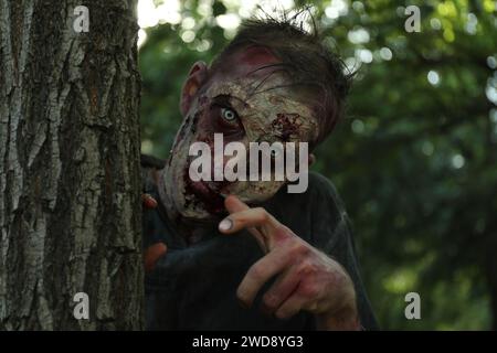 Scary zombie near tree outdoors. Halloween monster Stock Photo - Alamy