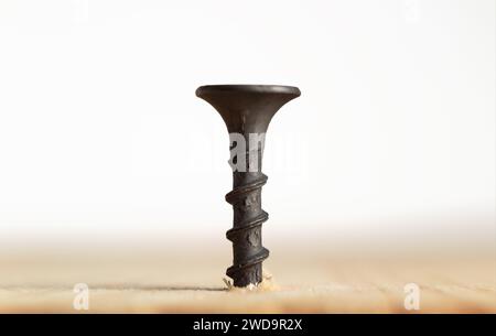 Screw screwed into a wooden Board on green background Stock Photo - Alamy