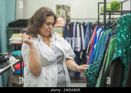 Caucasian fat woman chooses clothes. Plus size store Stock Photo - Alamy