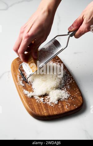 Man cooking with hard italian cheese, grated parmesan or grana padano ...