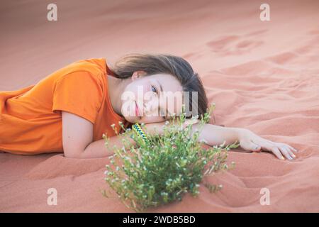 Young girl laying in the sand Stock Photo - Alamy