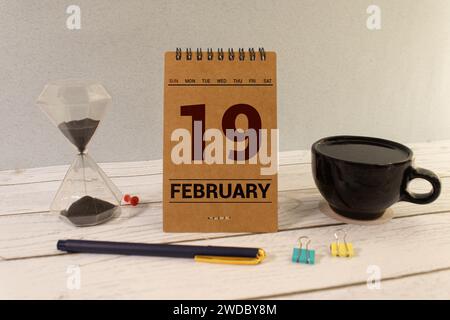 Cube shape calendar for February 19 on wooden surface with empty space ...