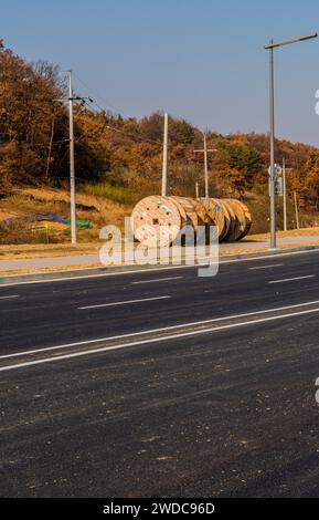 Large metal industrial spools sitting in front of evergreen tree Stock ...