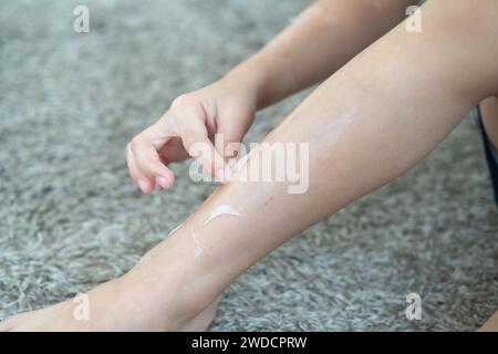 Little Asian boy's hands peeling off dry skin on his legs. Skin ...