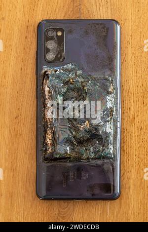 Smartphone destroyed by exploded lithium battery isolated on white ...