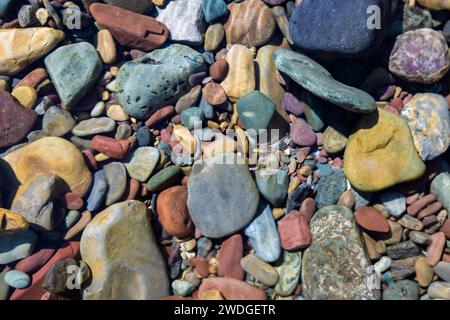 Naturally colorful river rocks under water in Glacier National Park ...