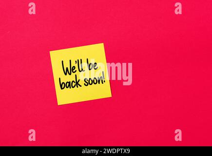 Handwritten we will be back soon message on yellow sticky note paper on ...