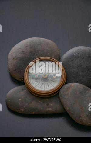 An antique brass compass laying on top of rocks Stock Photo - Alamy