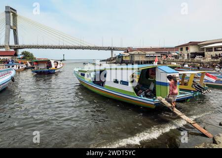Boats in Manado port and Soekarno Bridge in provincial capital of ...