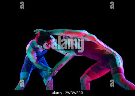 Young skilled wrestlers in blue and red uniform hand wrestling in ...