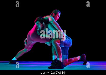 Young skilled wrestlers in blue and red uniform hand fighting in ...