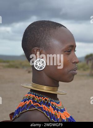 Female member of the Datoga tribe with shaven head in traditional dress ...