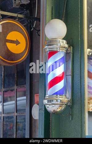 Rotating Spiral Lamp in Front of Barber Shop Pole Sign Stock Photo - Alamy