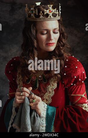 sad medieval queen in red dress with handkerchief and crown crying on ...