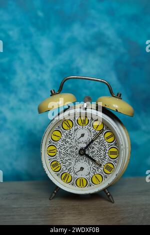 Wooden hand and clock on table near color wall Stock Photo - Alamy