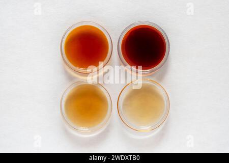 Different classes of maple syrups in different colours in glass dishes ...