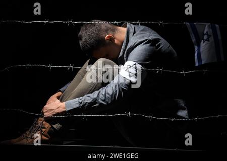Young Jewish man behind barbed wire on black background. International ...