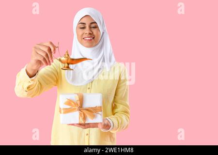 Muslim woman with gift box and Aladdin lamp for Ramadan on white ...