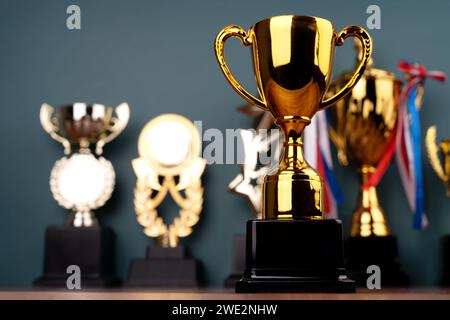 Gold Trophy with a row of gold trophy background Stock Photo - Alamy