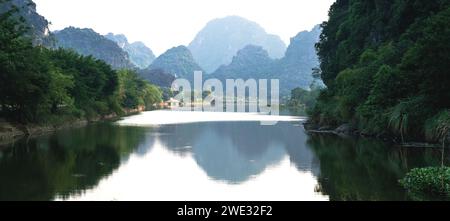 Karst limestone mountains along river with lush vegetation in Ninh Binh ...