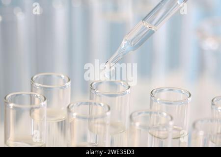 Laboratory analysis. Dripping liquid from pipette into glass test tube ...