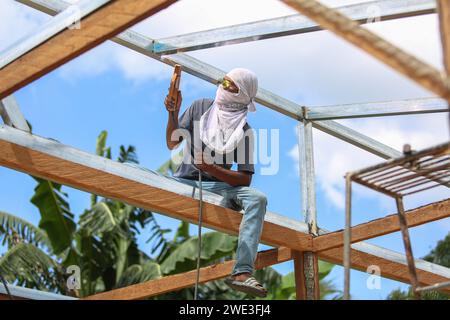 Filipino construction worker welding on roof metal structure of a Bahay ...