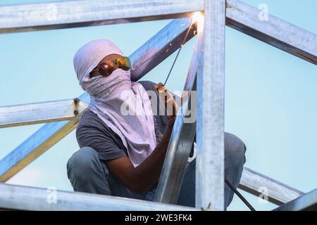 Filipino construction worker welding on roof metal structure of a Bahay ...