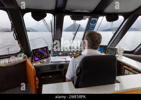 Ship’s captain guiding a Realnz catamaran passenger ferry on Lake ...