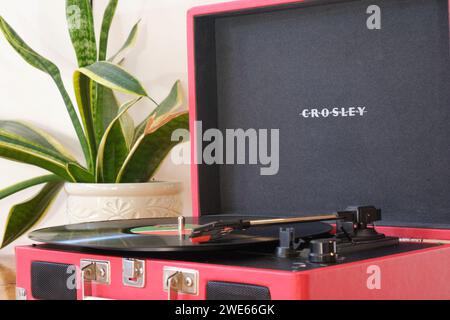 retro looking red Crosley record-player, with vinyl record on turn ...