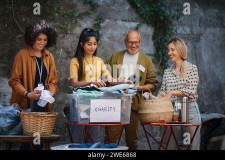 People sorting used clothes for charity Stock Photo - Alamy