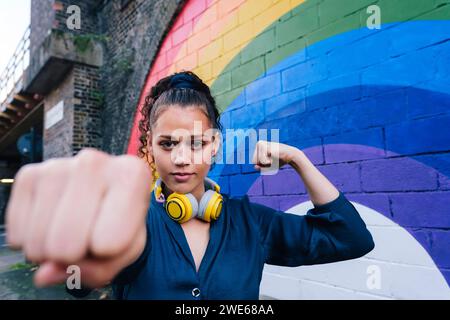 Woman punching with fist and flexing muscle in front of wall Stock ...
