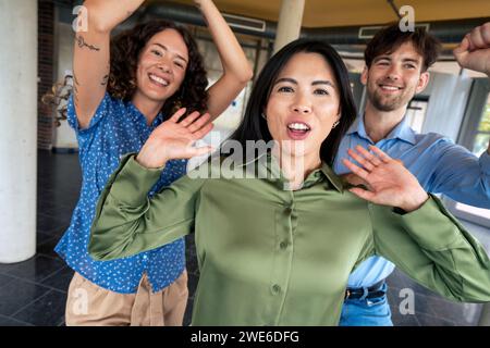 Happy multiracial business colleagues dancing together in office Stock ...