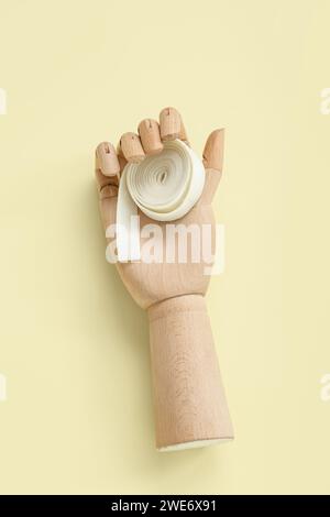 Wooden hand with chewing gum on light yellow background Stock Photo - Alamy