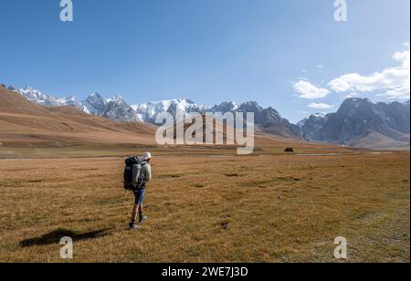 Mountaineer hiking to the mountain lake Kol Suu, mountain landscape ...