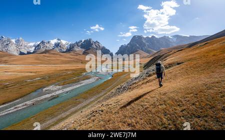 Mountaineer hiking to the mountain lake Kol Suu, mountain landscape ...