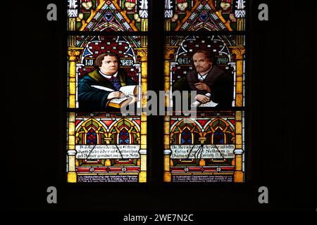 Colourful stained glass window with reformers Johannes Calvin and ...