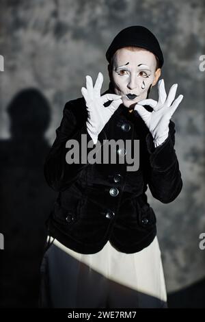 Dramatic vertical portrait of female mime artist performing on stage in ...