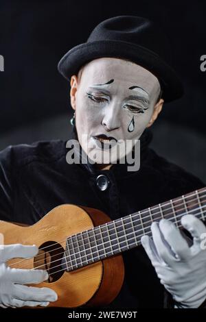 Dramatic vertical portrait of female mime artist performing on stage in ...