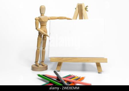 Wooden doll with empty easel on white background; business or creative ...
