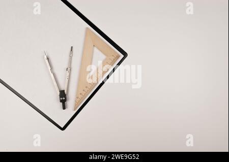 Triangle ruler and compass on white background Stock Photo - Alamy