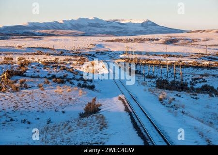 Railroad tracks through a snow covered rocky forest landscape Stock ...
