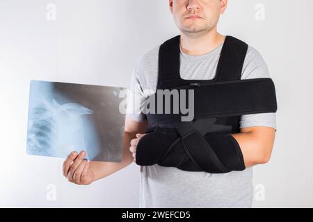 A man in a black bandage supporting the shoulder joint after ligament ...