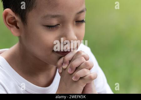 Little boy with Bible praying and close your eyes in praying. Prayer to ...