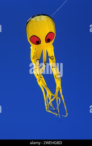 Yellow Kite in shape of an octopus with red eyes in the air Stock Photo ...