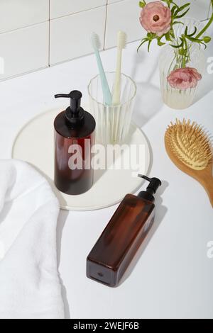 Hair brush, comb, towel and bottles of essential oil on color ...