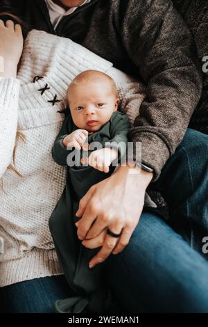Newborn baby boy cuddled by mom and dad on the couch Stock Photo - Alamy