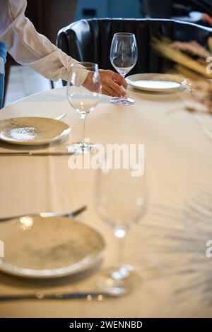 Waitress in white jacket serves a table in restaurant hall Stock Photo ...