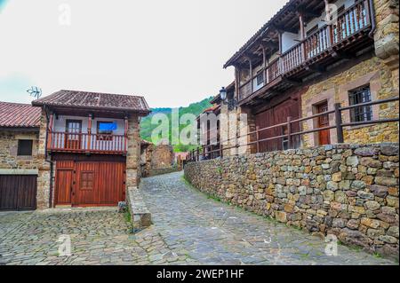 A serene, cobblestone-lined path flanked by traditional stone houses ...
