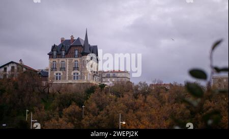 A castle stands amidst a forest-covered hill, at Biarritz, France Stock ...