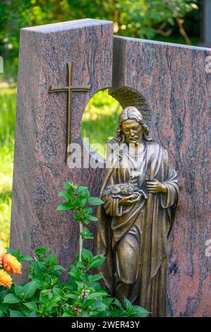 Decorated grave with a gravestone with cross and "The Good Shepherd ...